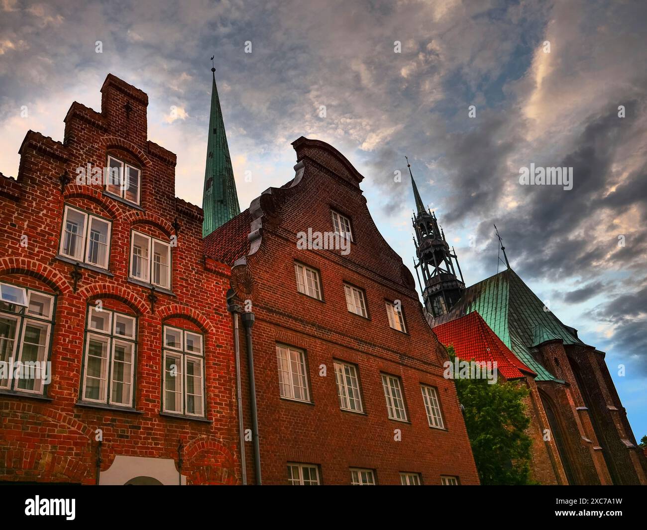 Historic buildings with towers and red bricks under a dramatic cloudy ...