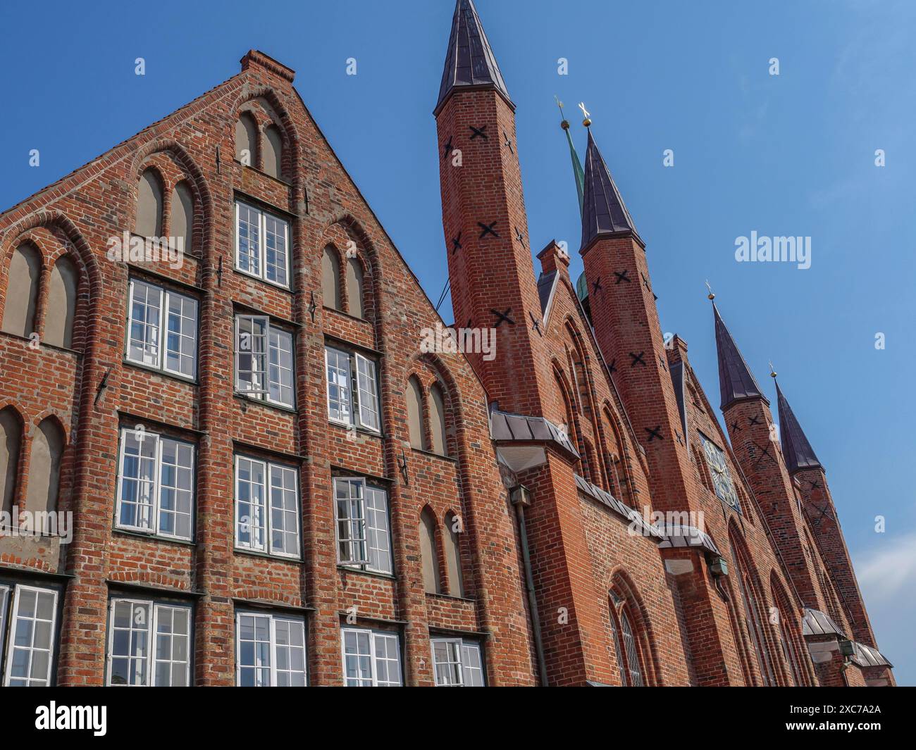Several historic brick buildings, towers rise into the blue sky, Gothic ...