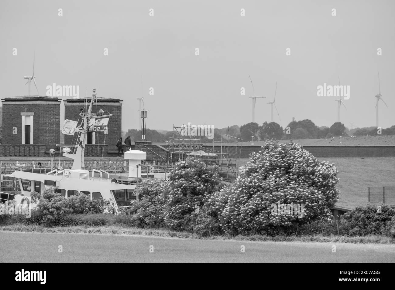 Black and white photo of buildings, wind turbines and boats in a green ...