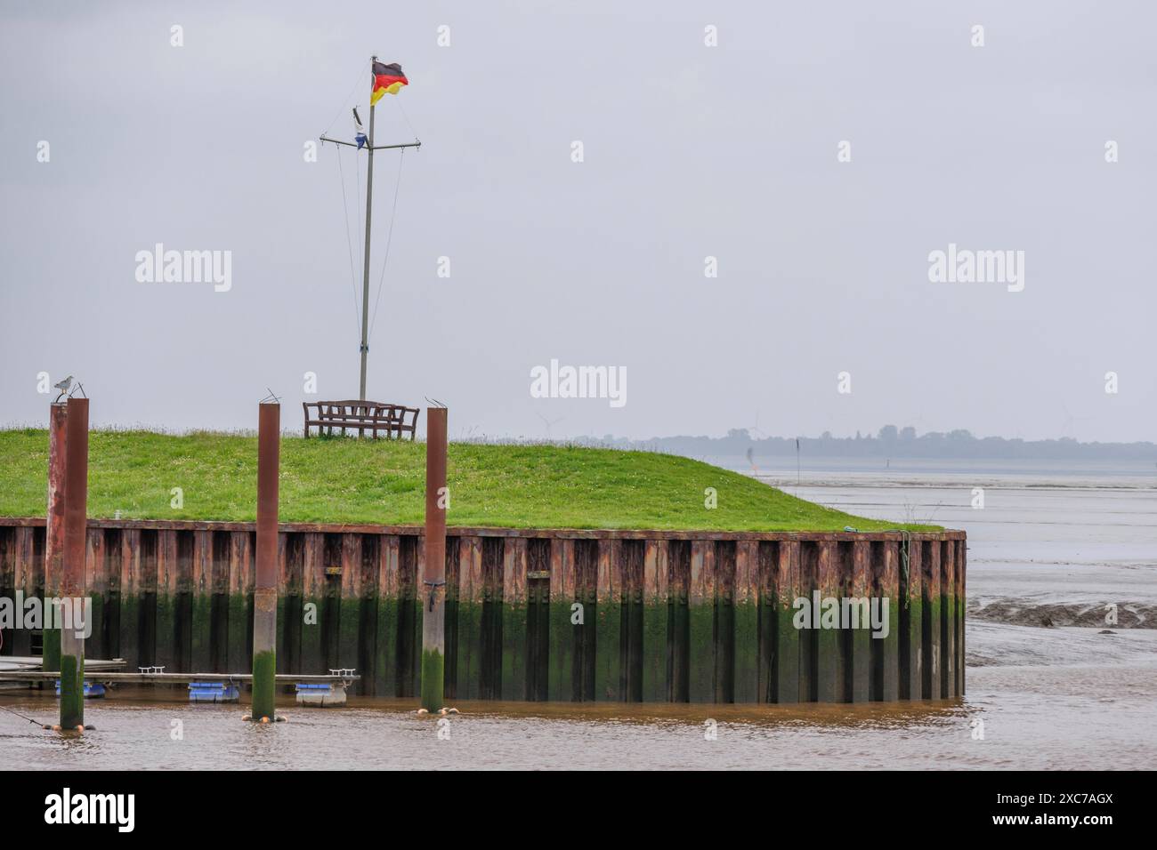 A jetty with a German flag over a river on a grey day, dangast, varel ...