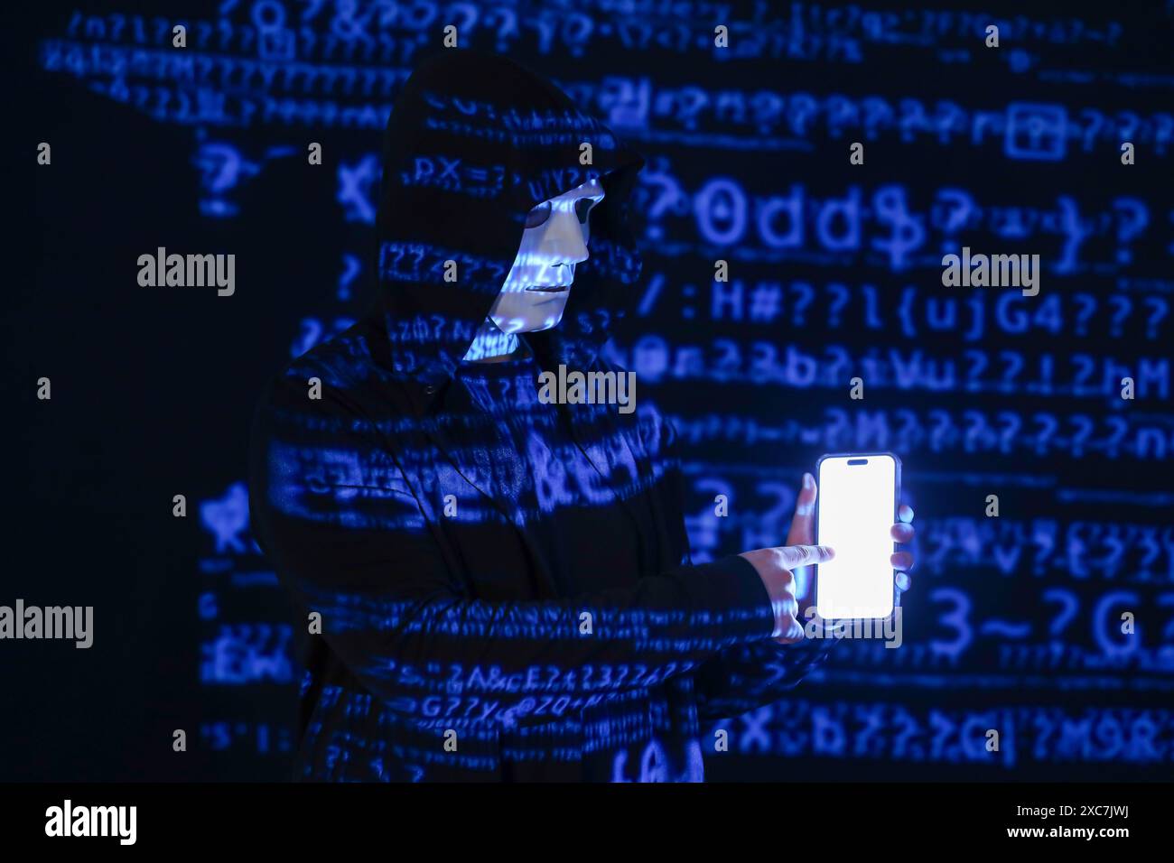 Hacker with mobile phone and projection of programming code on dark ...