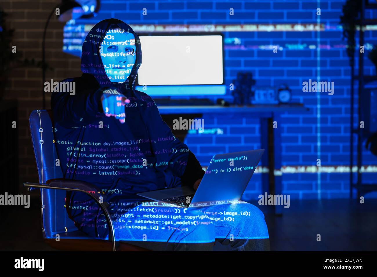 Hacker with laptop and projection of programming code pointing at ...