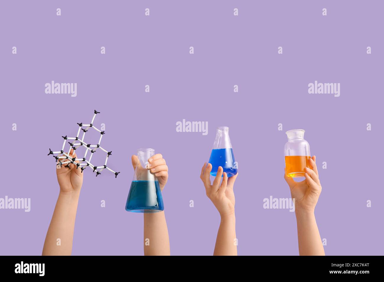 Female hands holding molecular model with filled flasks on lilac ...