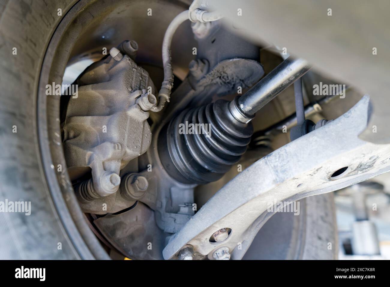 Closeup car's suspension system, focusing on the axle and CV joint area ...