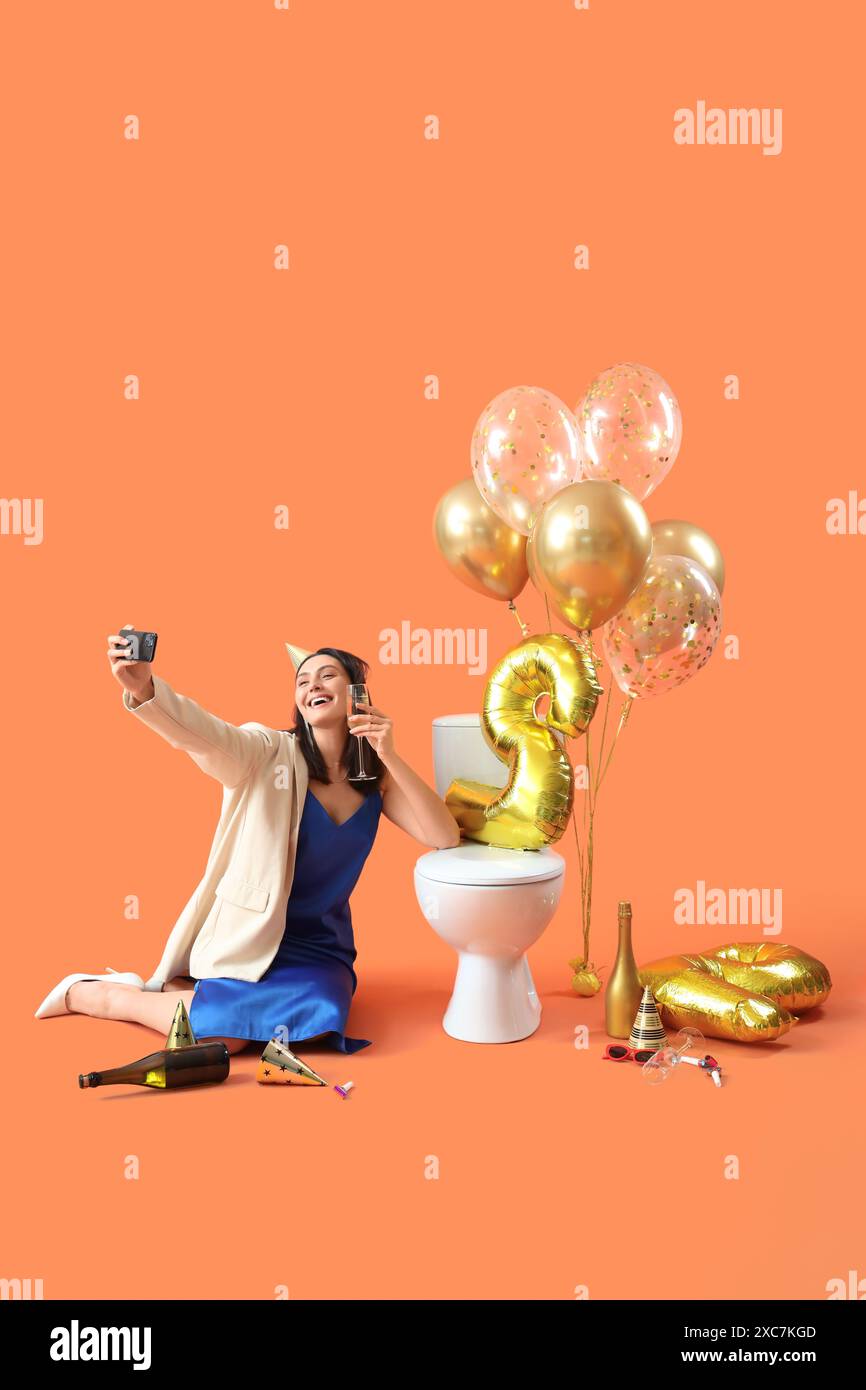 Drunk young woman with champagne taking selfie near toilet bowl after ...
