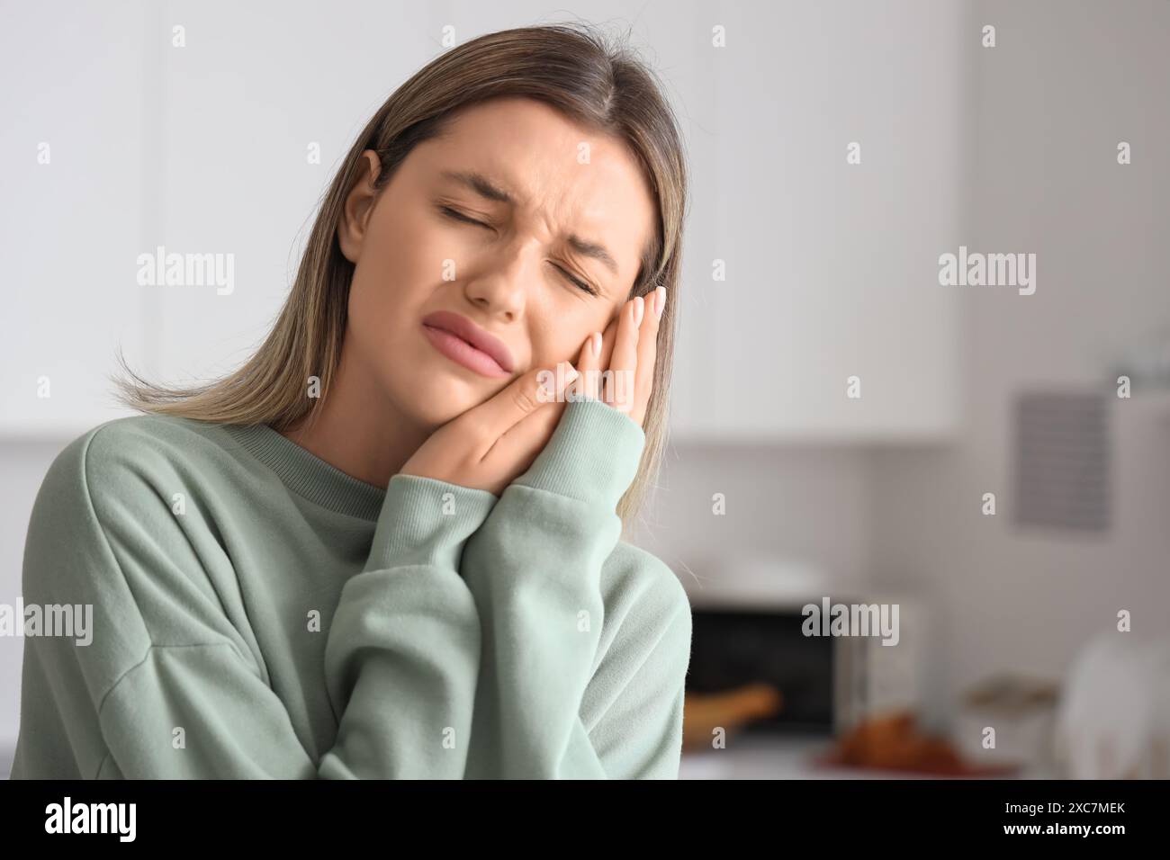 Young woman suffering from tooth ache at home Stock Photo - Alamy