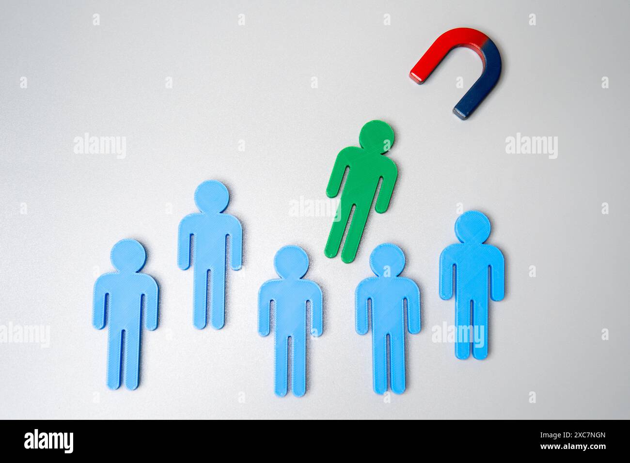 Magnet attracts human figure from the crowd. Talent acquisition, hiring ...
