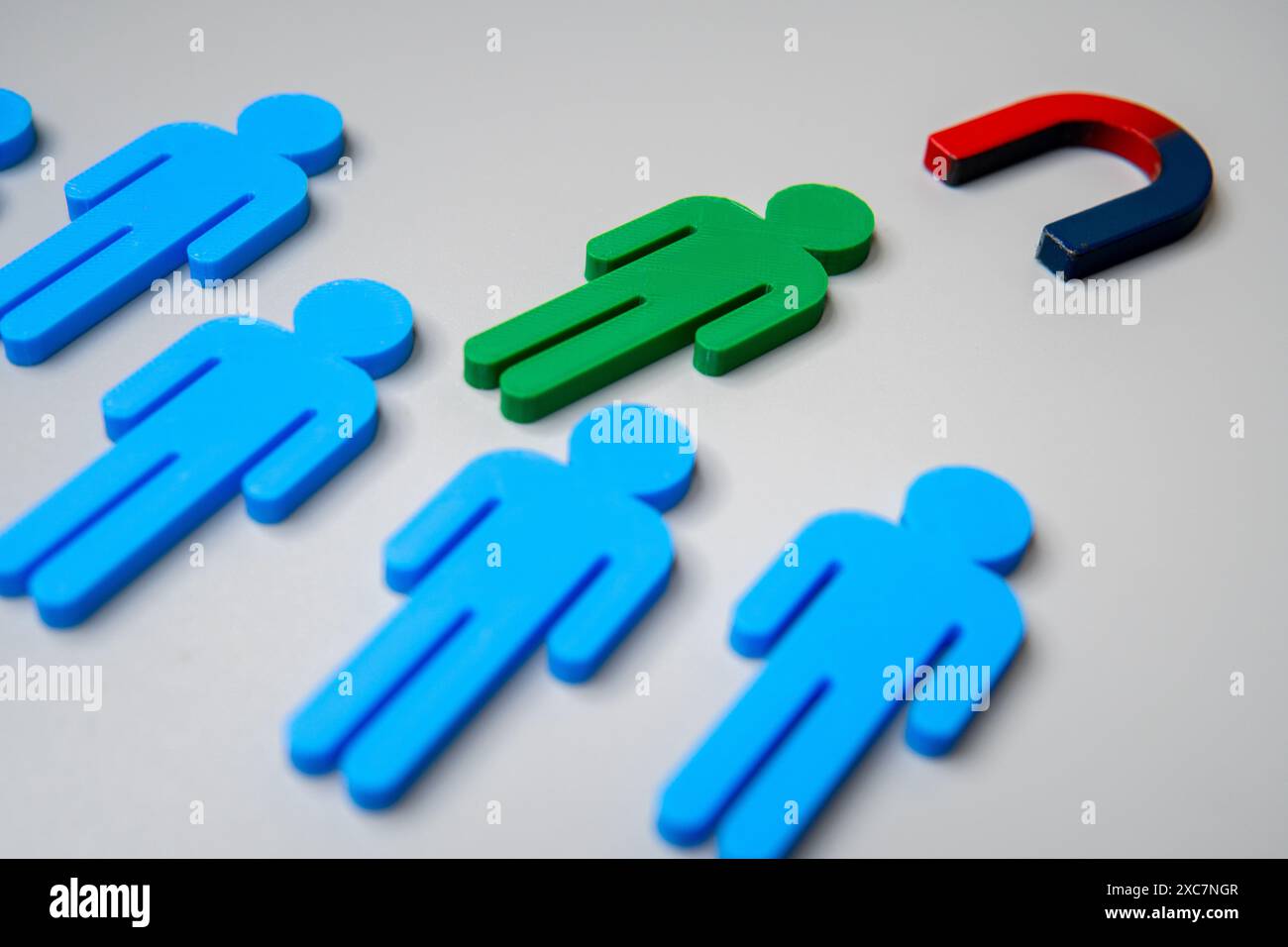Magnet attracts human figure from the crowd. Talent acquisition, hiring ...