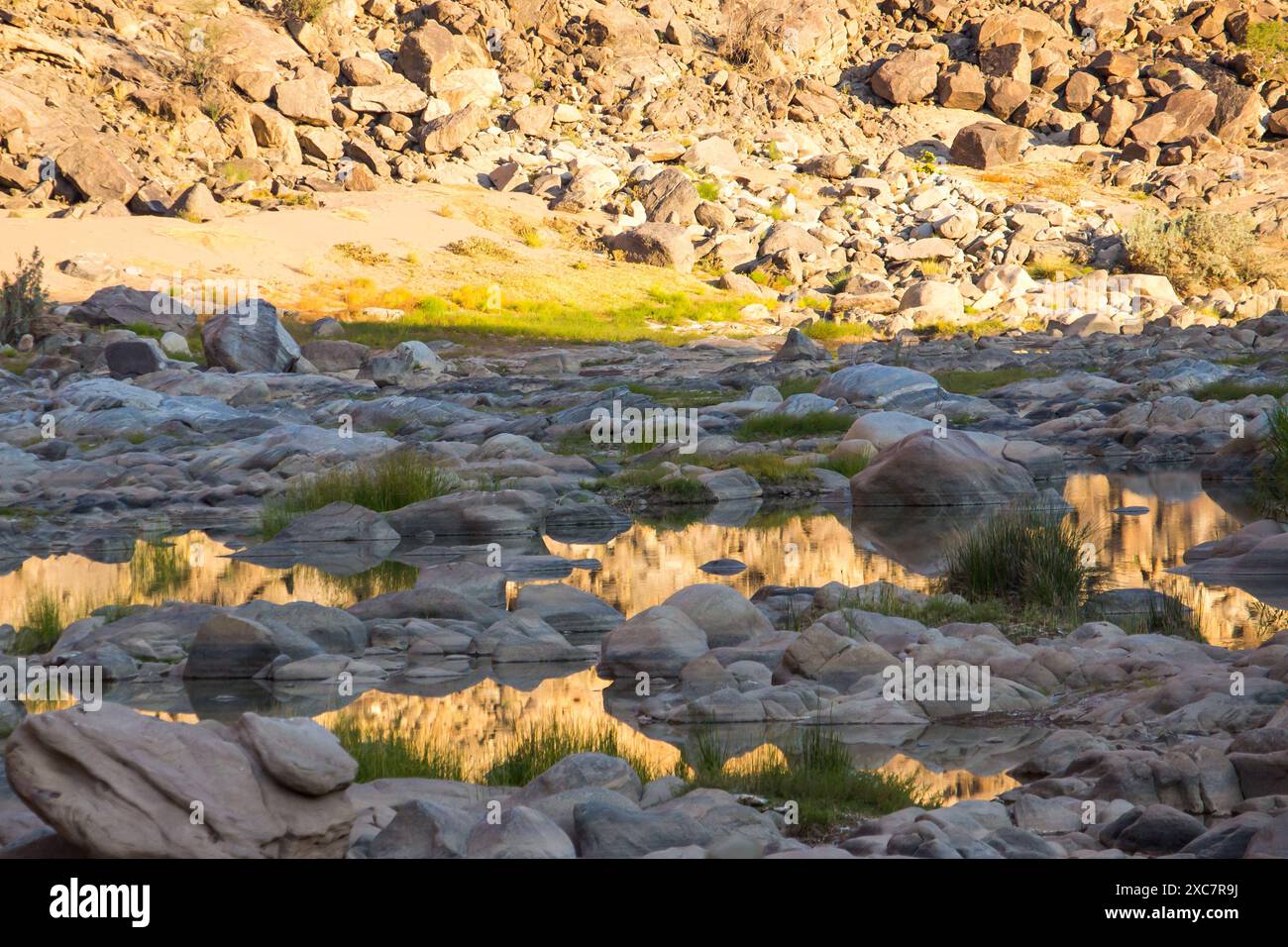 Golden Reflection of the cliffs of the Fish River Canyon into the river in the late afternoon ...