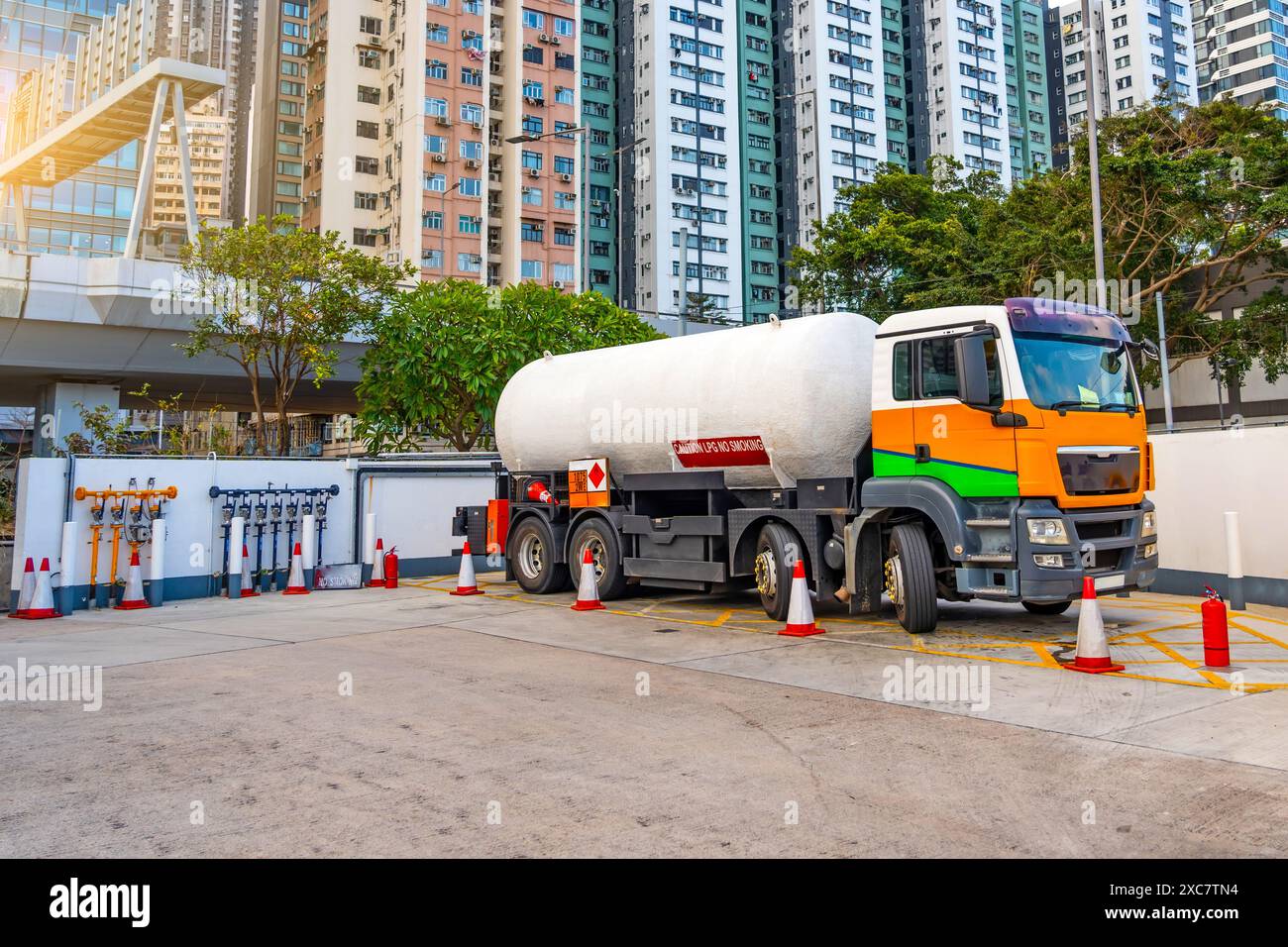 Tanker gas truck delivering fuel at service station against residential ...