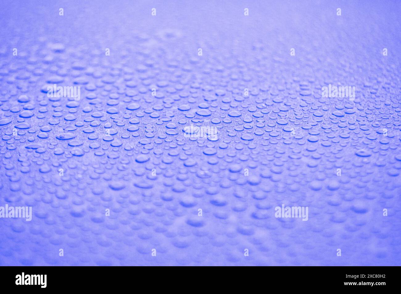 Side view of water droplets on blue background Stock Photo - Alamy