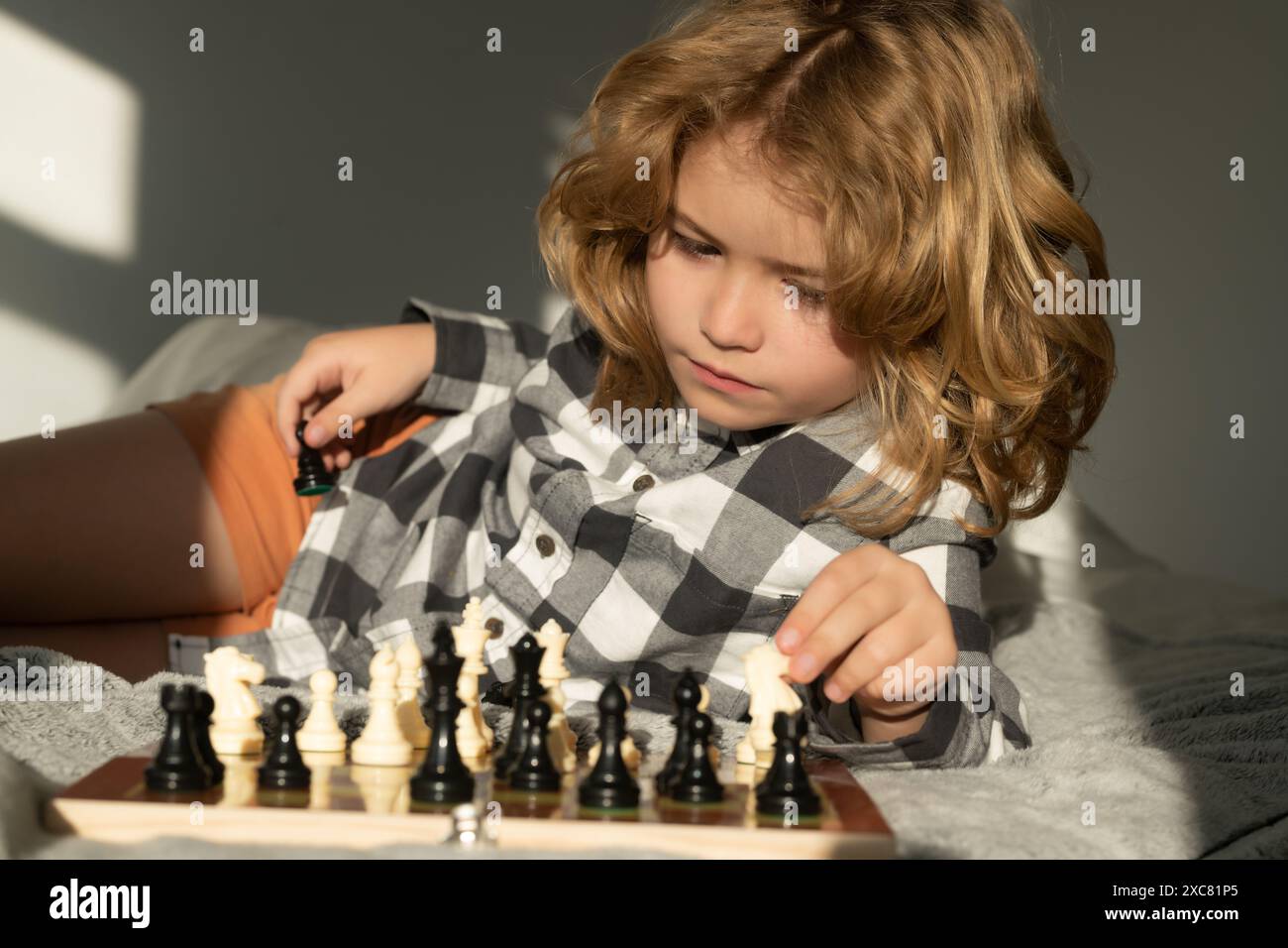 Child playing chess at home. Clever concentrated and thinking kid ...