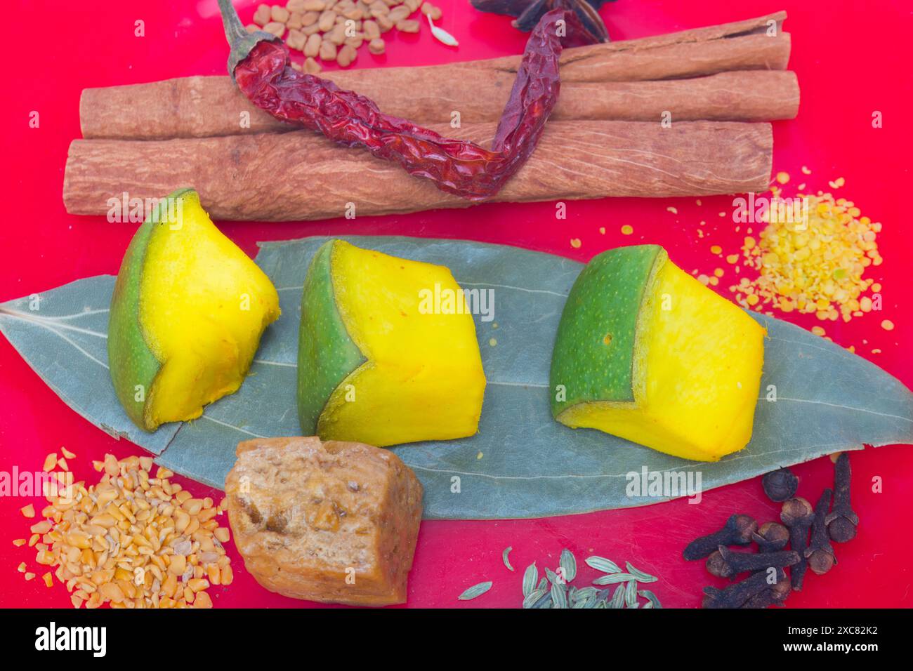 On a red plate, arrange the Indian spices are used in mango pickles ...