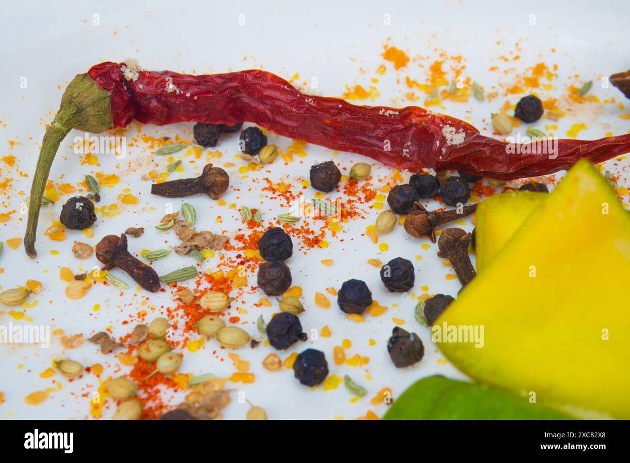 very close-up left side view of sprinkled Indian spices, like red ...