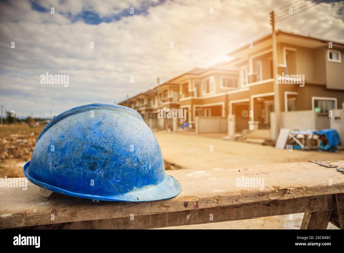 Blue hard hat on house building construction site Stock Photo - Alamy