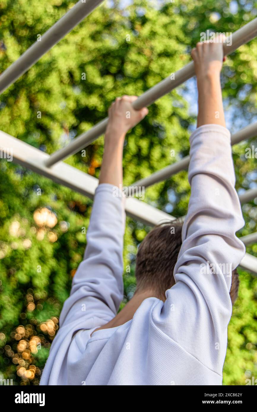 Hanging from playground bars hi-res stock photography and images - Alamy