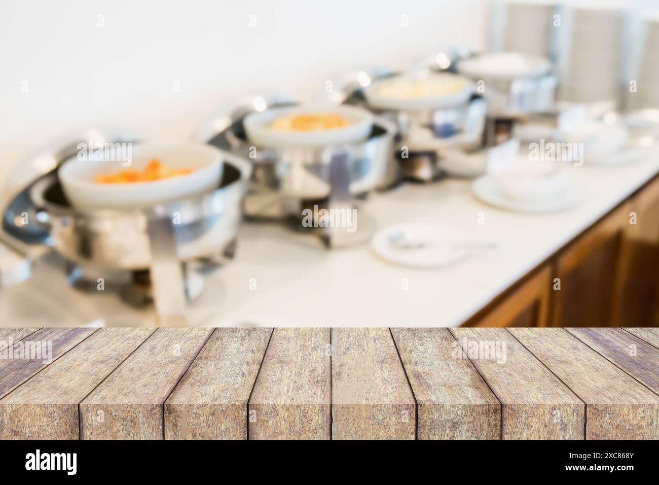 wood table with Many buffet heated trays in the hotel restaurant blur ...