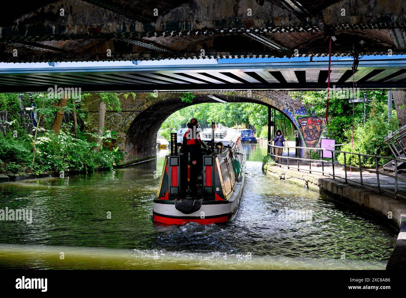 London, UK. Barge passing under a bridge near Camden Lock on the ...