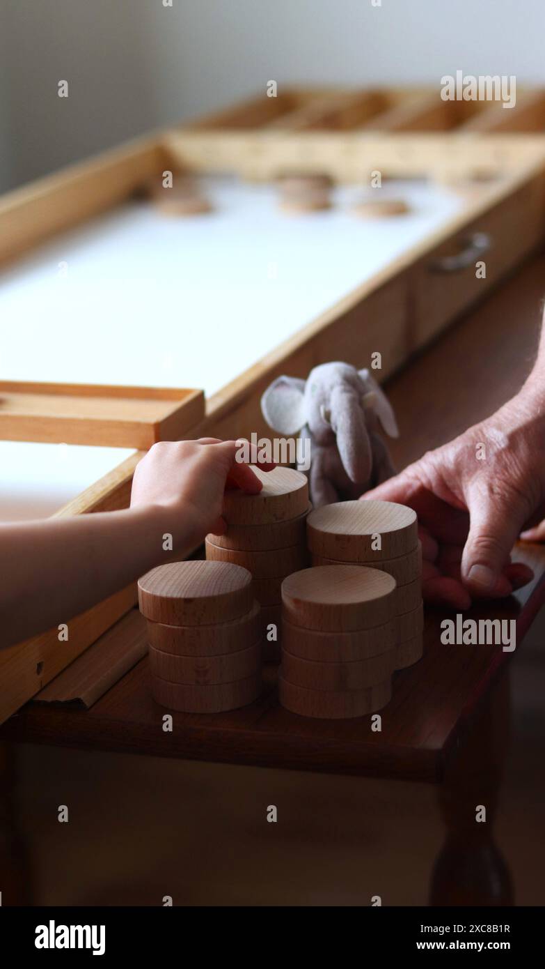 wooden board game sjolen, plush elephant, young and old hands touching ...