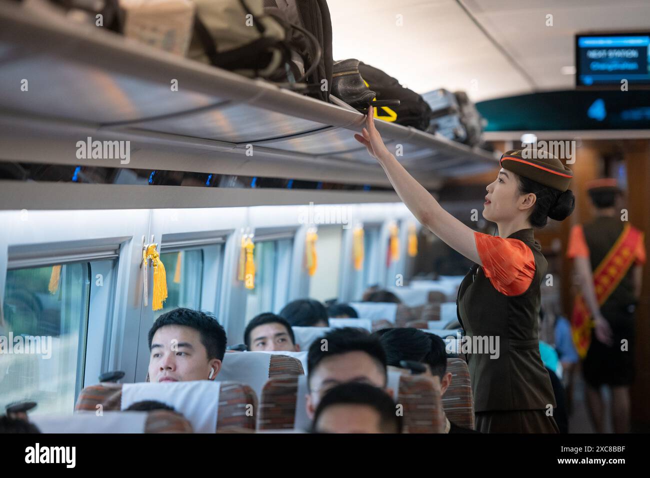 Wuhan, China. 15th June, 2024. A train attendant checks the luggage ...