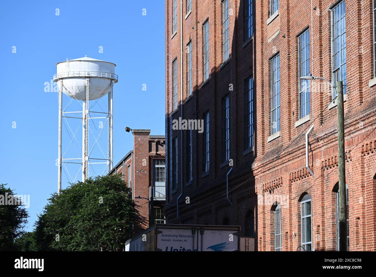 A water tower rises above old tobacco warehouses converted into living ...