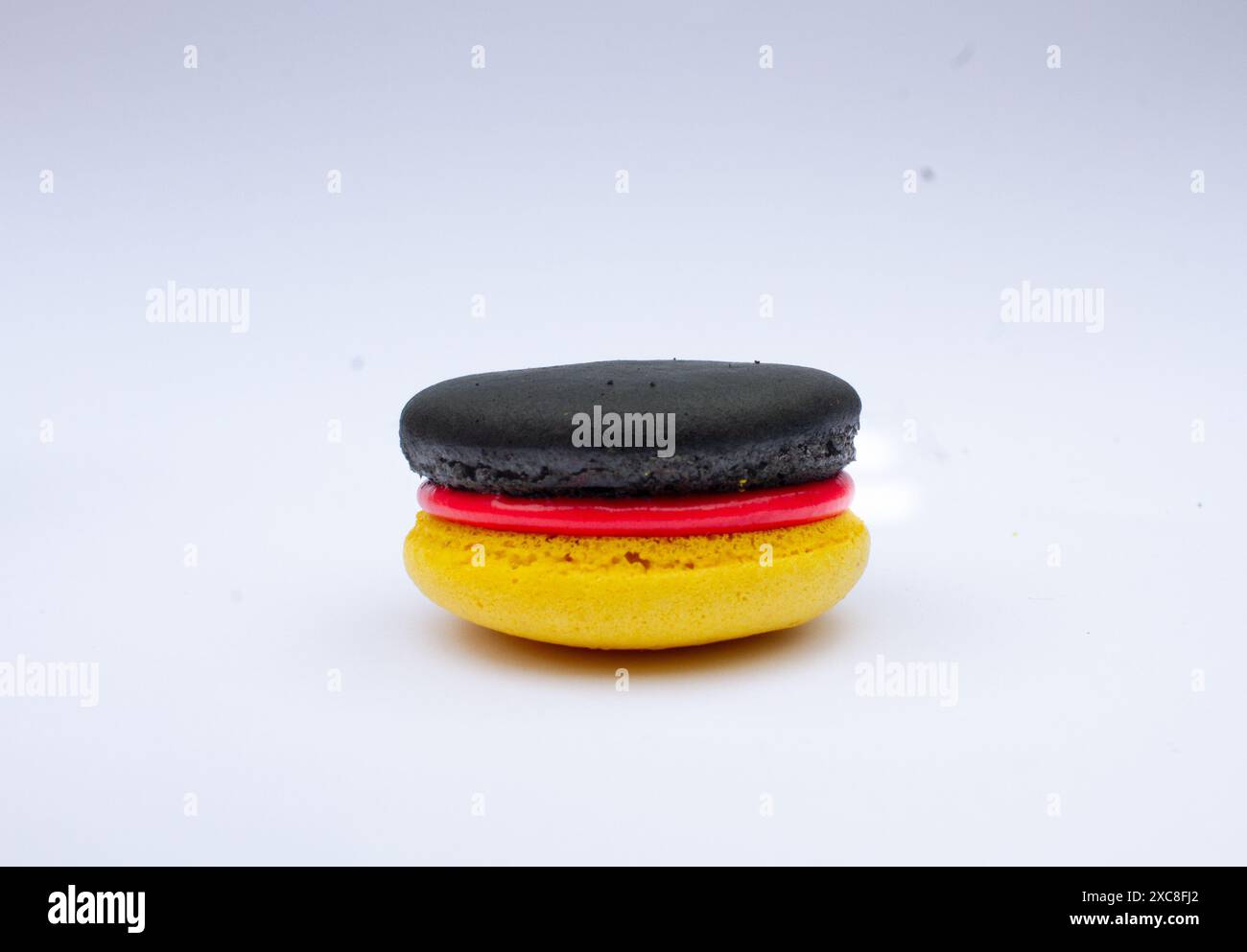 A macroon in german national colors red, gold, black on a light ...