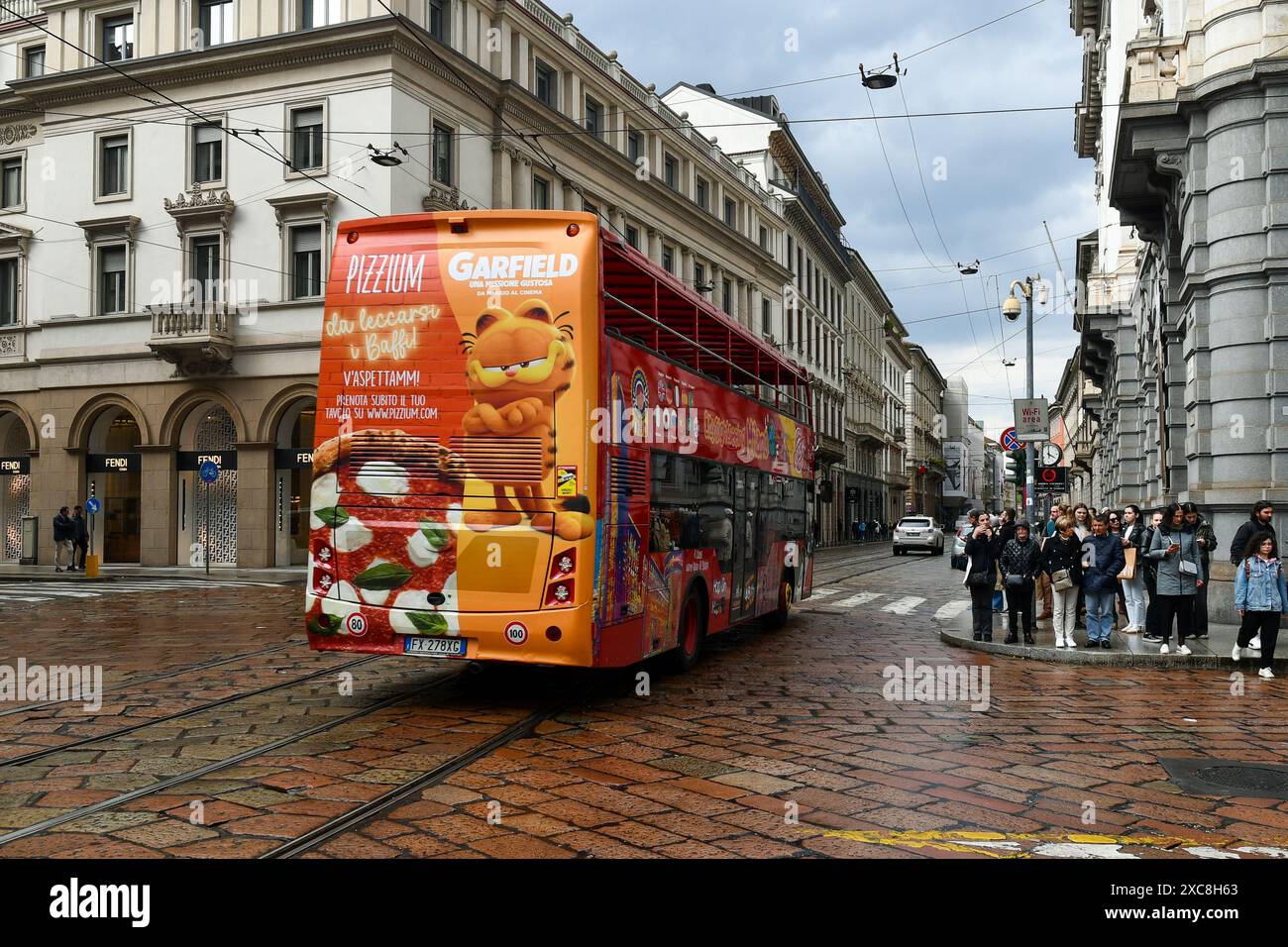 A colorful city sightseeing bus passing in Via Alessandro Manzoni in ...