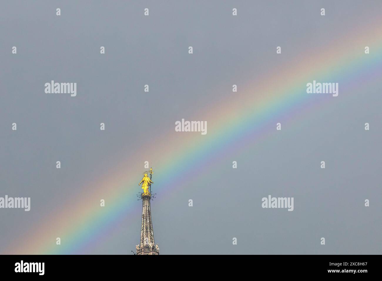 The Madonnina statue atop Milan Cathedral against a rainbow sky, Milan ...