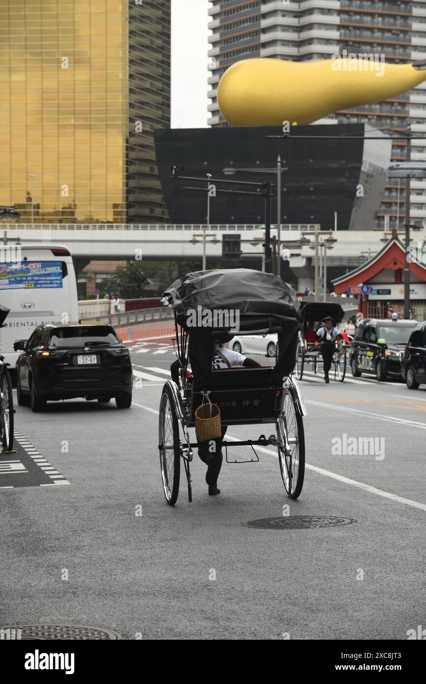 Japanese man carrying a typical japanese rickshaw with tourists on the ...