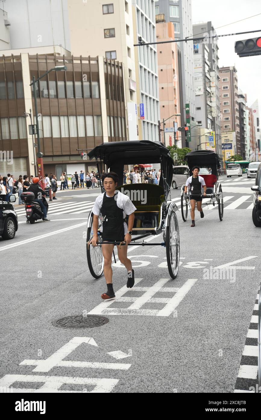 Japanese man carrying a typical japanese rickshaw with tourists on the ...