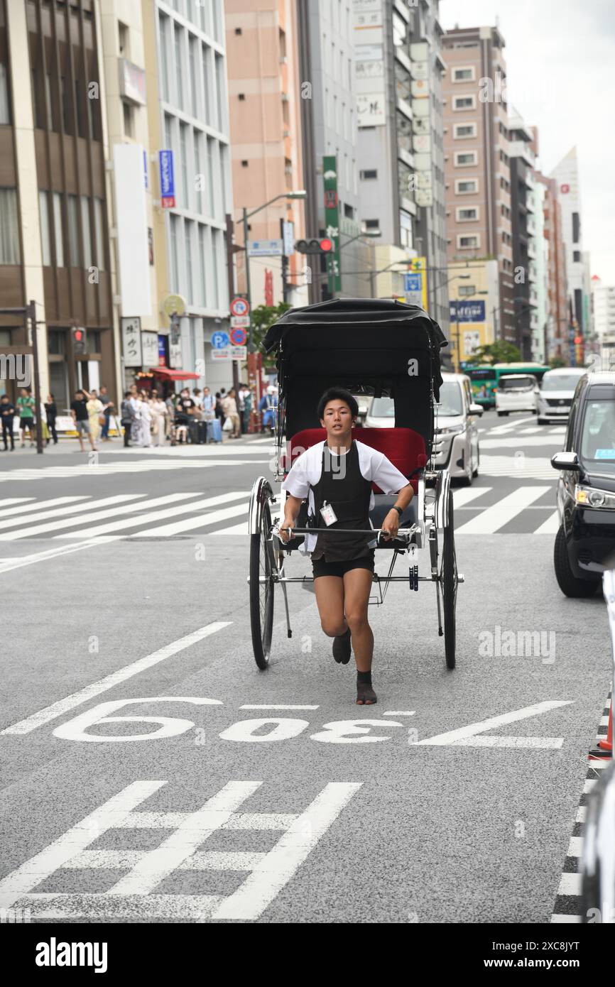 Japanese man carrying a typical japanese rickshaw with tourists on the ...