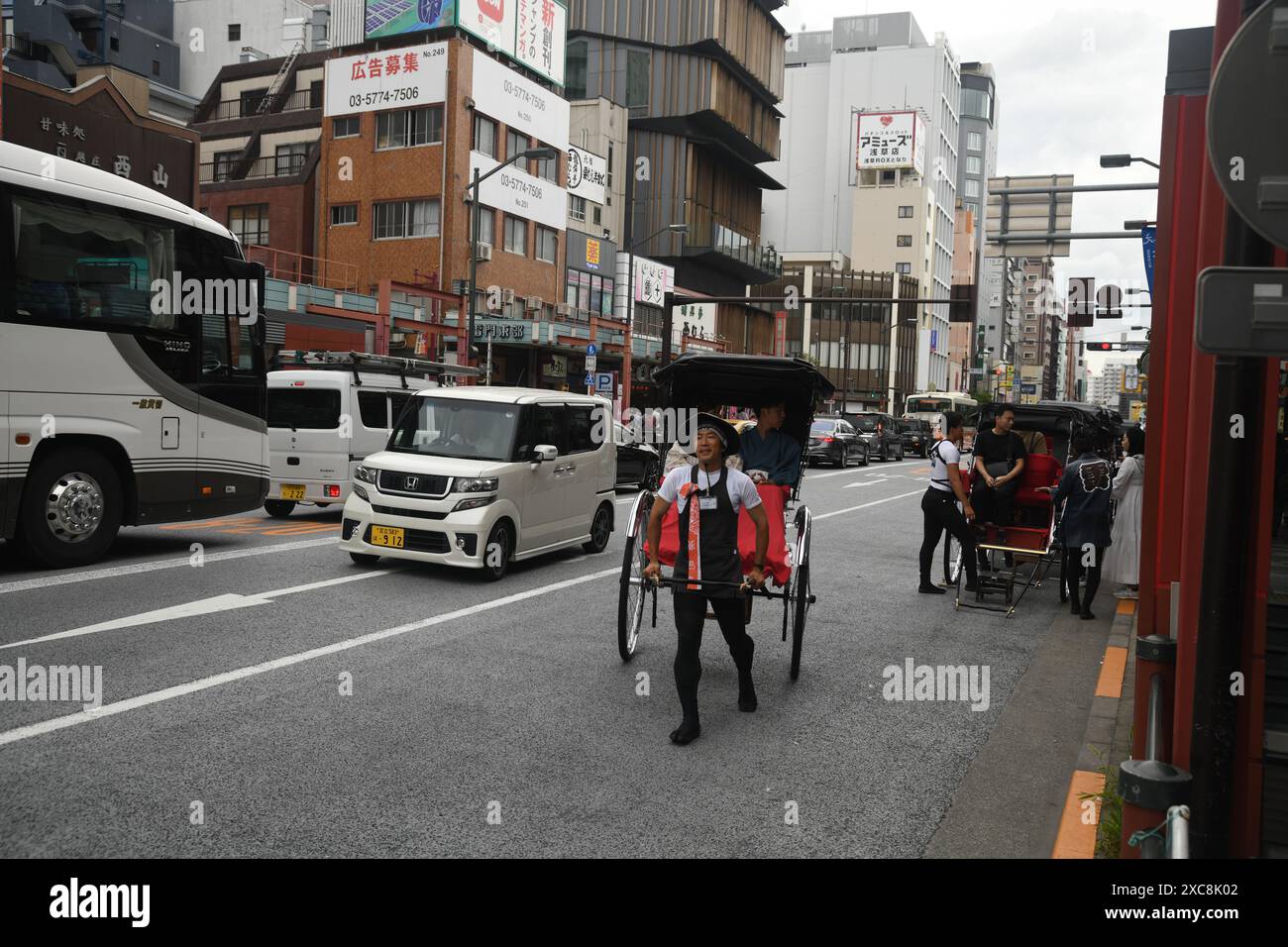 Japanese man carrying a typical japanese rickshaw with tourists on the ...