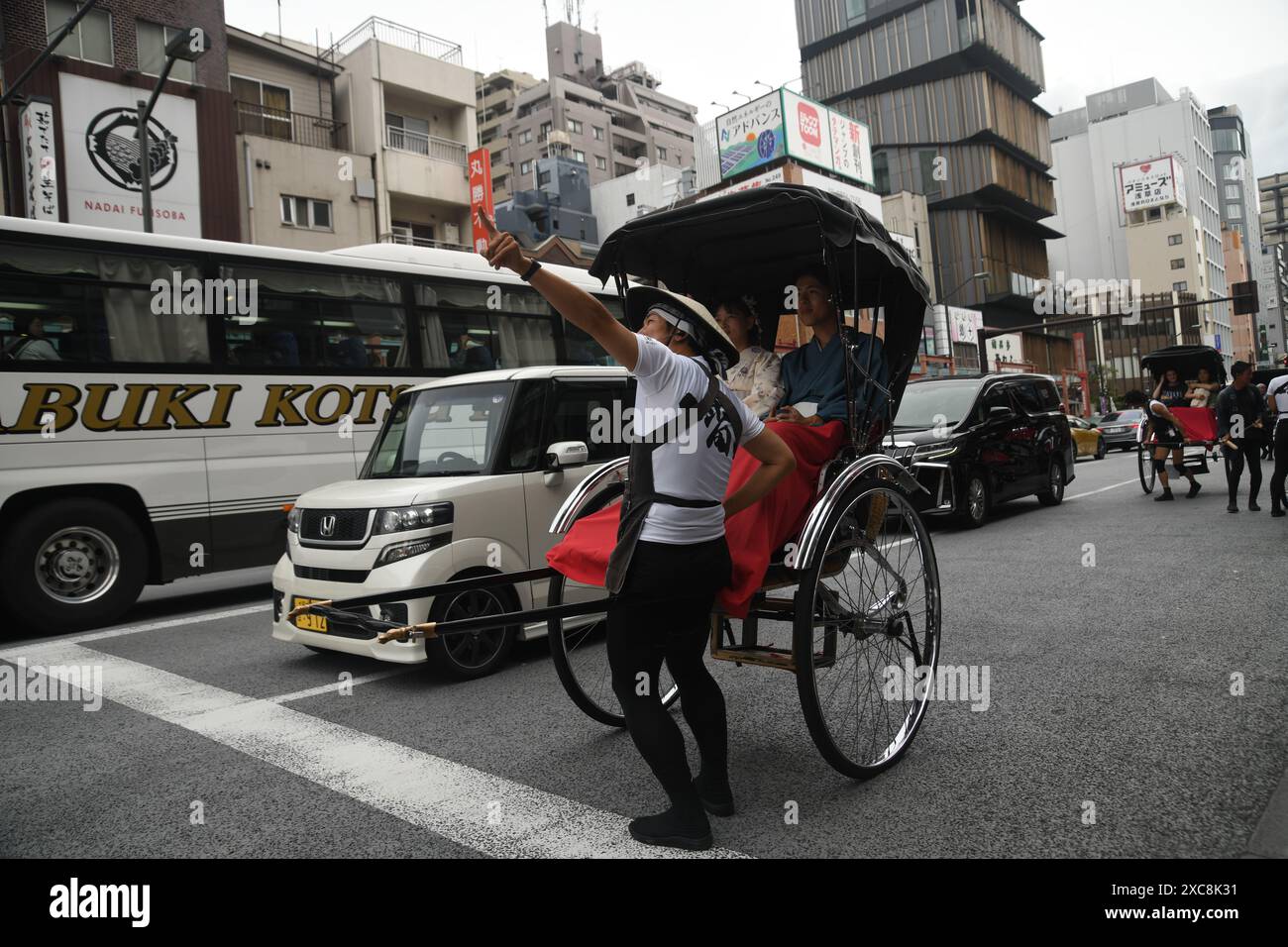 Japanese man carrying a typical japanese rickshaw with tourists on the ...