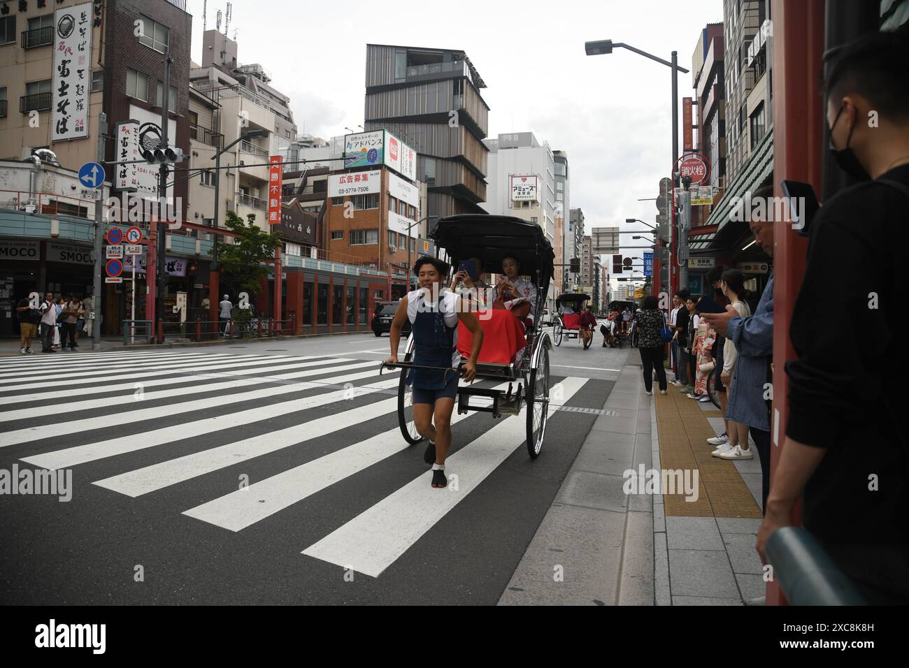 Japanese man carrying a typical japanese rickshaw with tourists on the ...