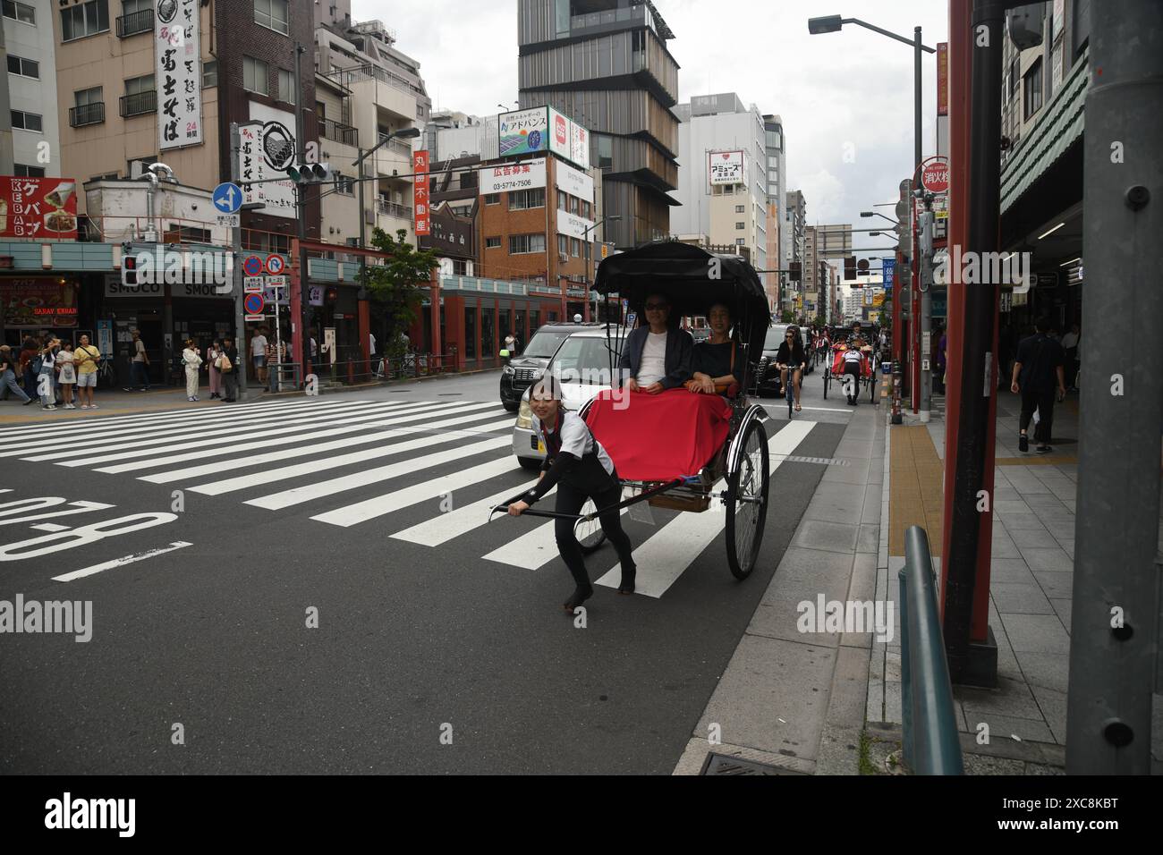 Japanese man carrying a typical japanese rickshaw with tourists on the ...