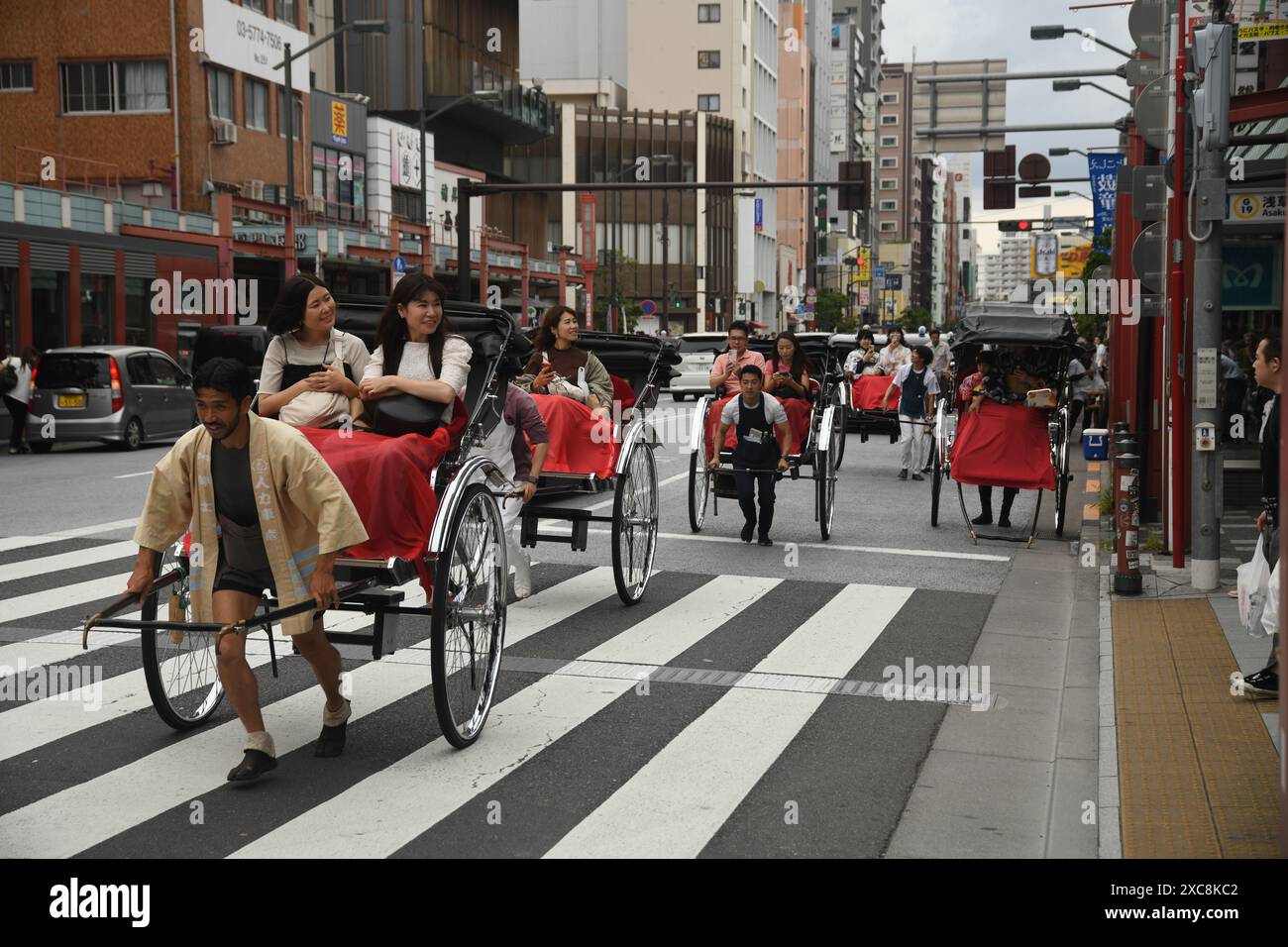 Japanese man carrying a typical japanese rickshaw with tourists on the ...