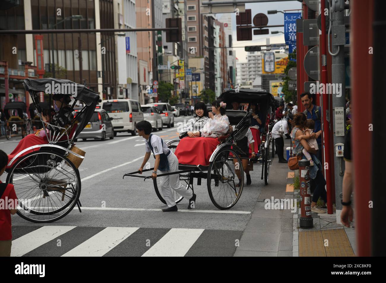 Japanese man carrying a typical japanese rickshaw with tourists on the ...
