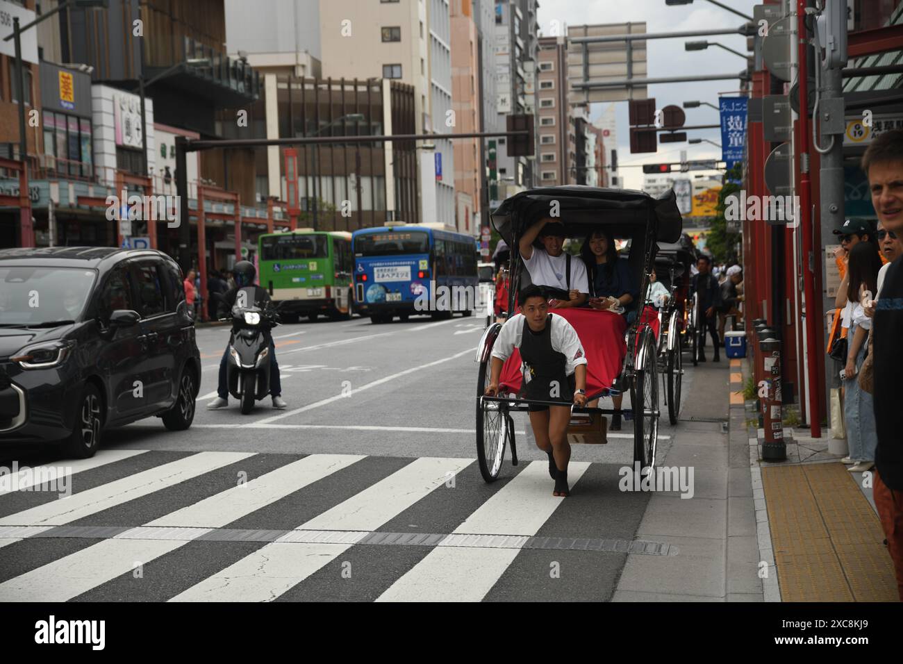 Japanese man carrying a typical japanese rickshaw with tourists on the ...