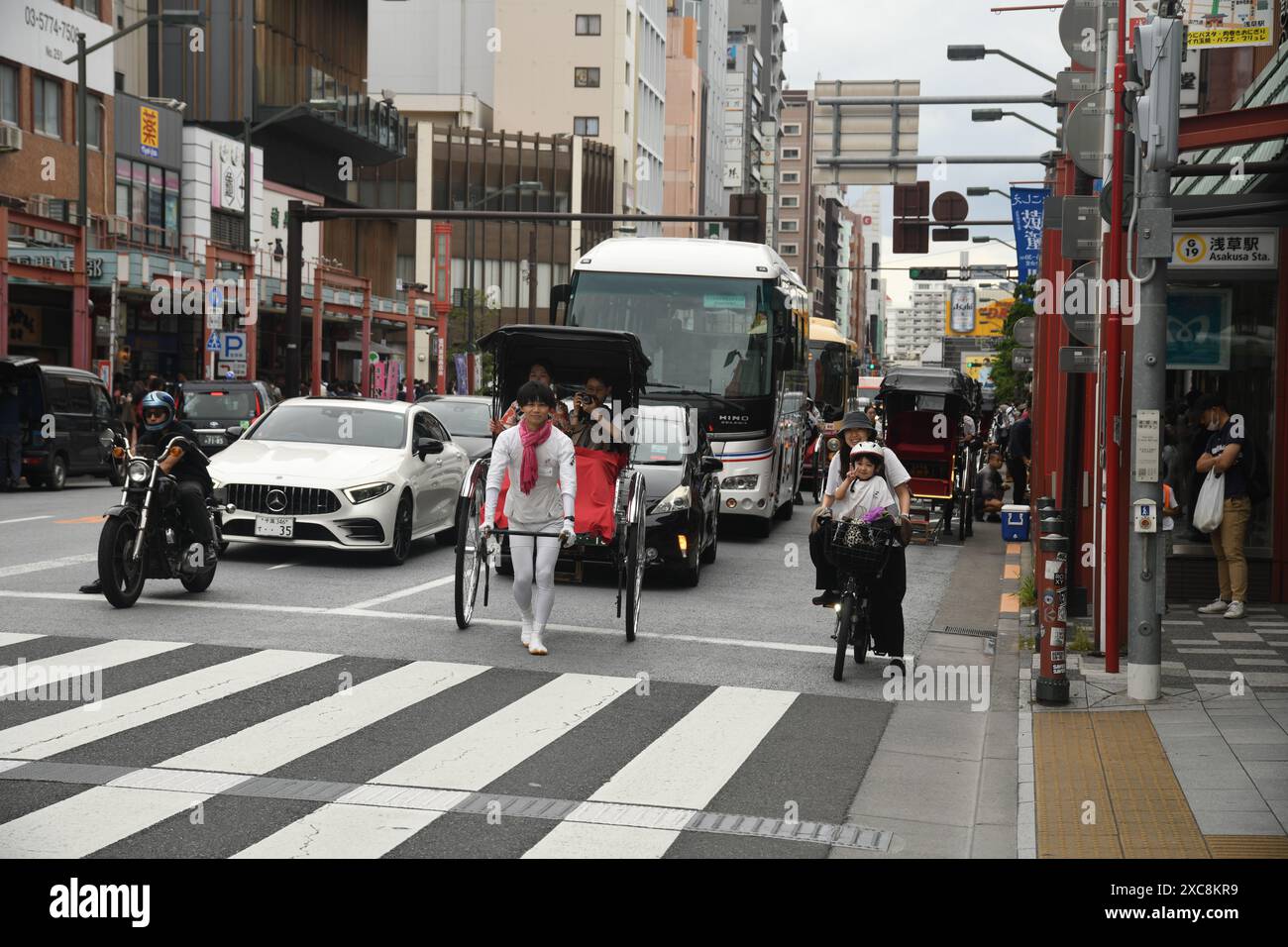 Japanese man carrying a typical japanese rickshaw with tourists on the ...