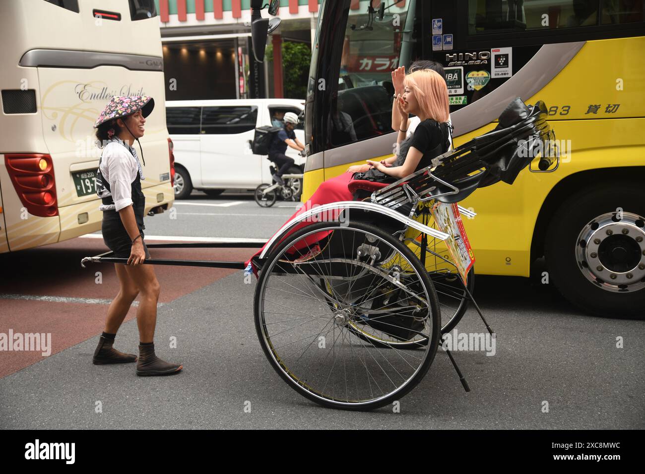 Japanese man carrying a typical japanese rickshaw with tourists on the ...