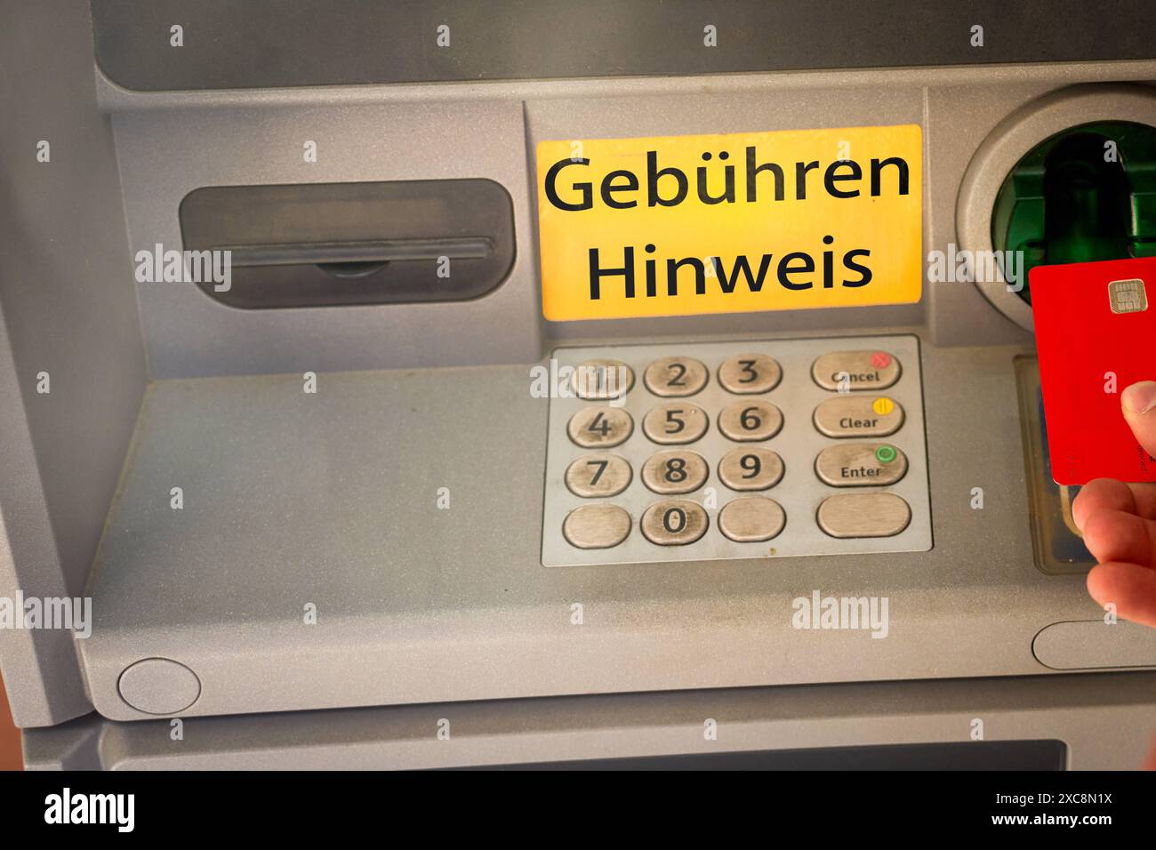 13 June 2024: An ATM with the inscription: Fees Notice. A man inserts ...