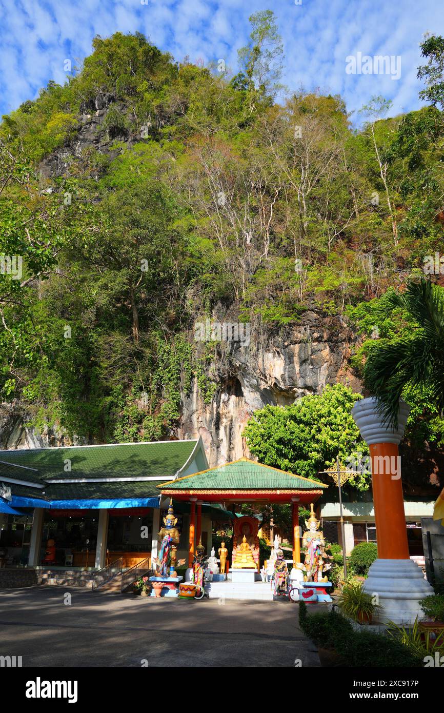 Shrine with lots of sacred statues at the bottom of a limestone karst ...