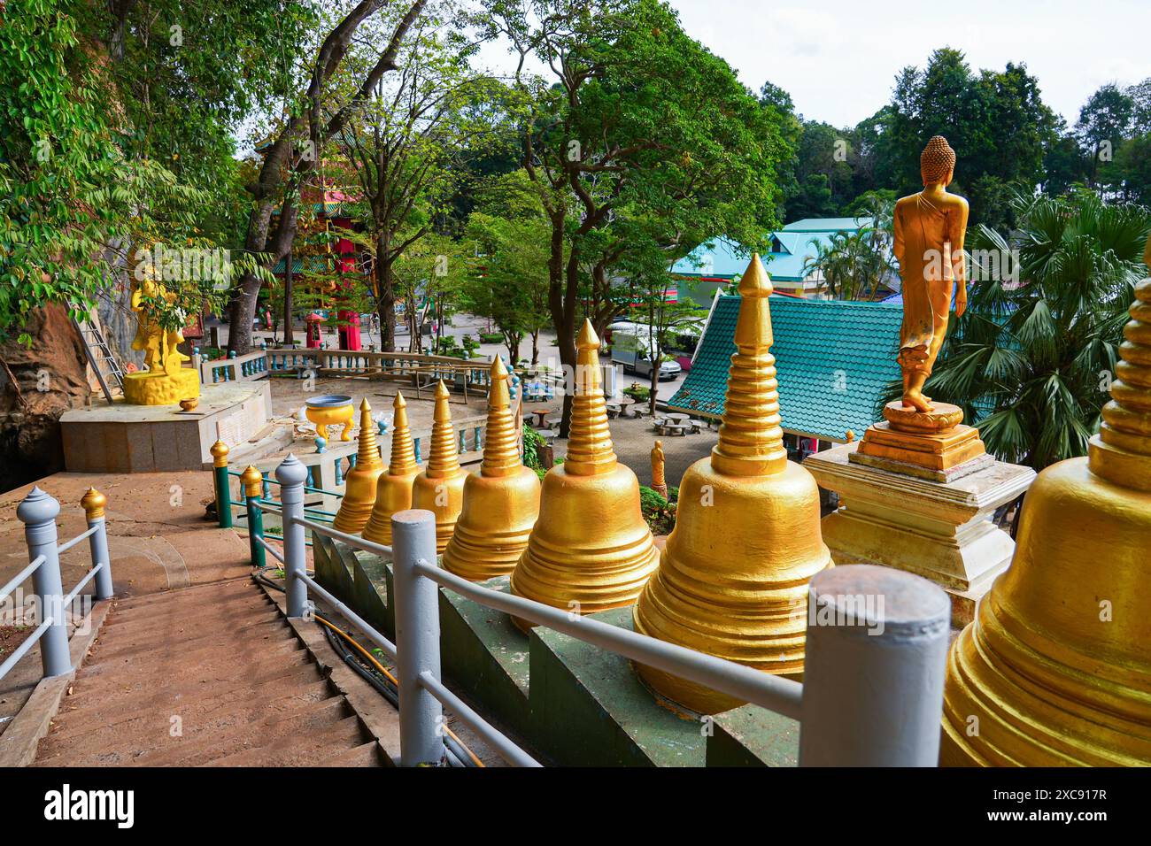 Steep stairs climbing up a limestone karst cliff through the rainforest ...