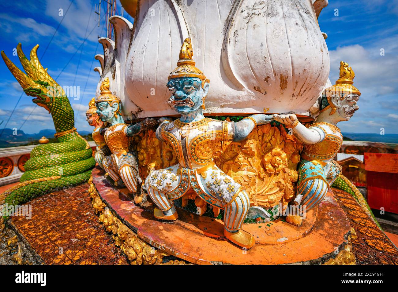 Thai demons holding the giant statue of Buddha at the hilltop pagoda of ...