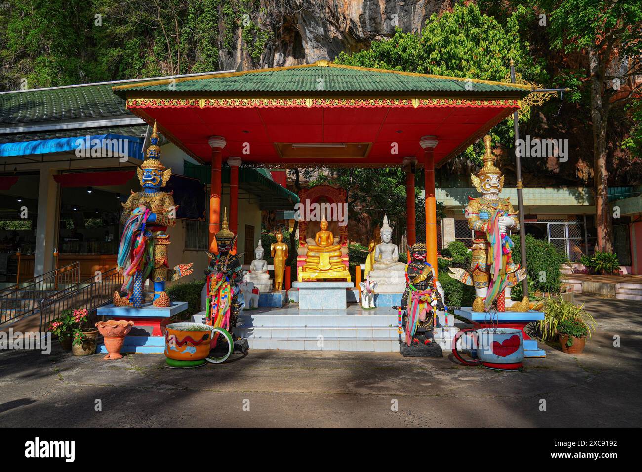 Shrine with lots of sacred statues at the bottom of a limestone karst ...