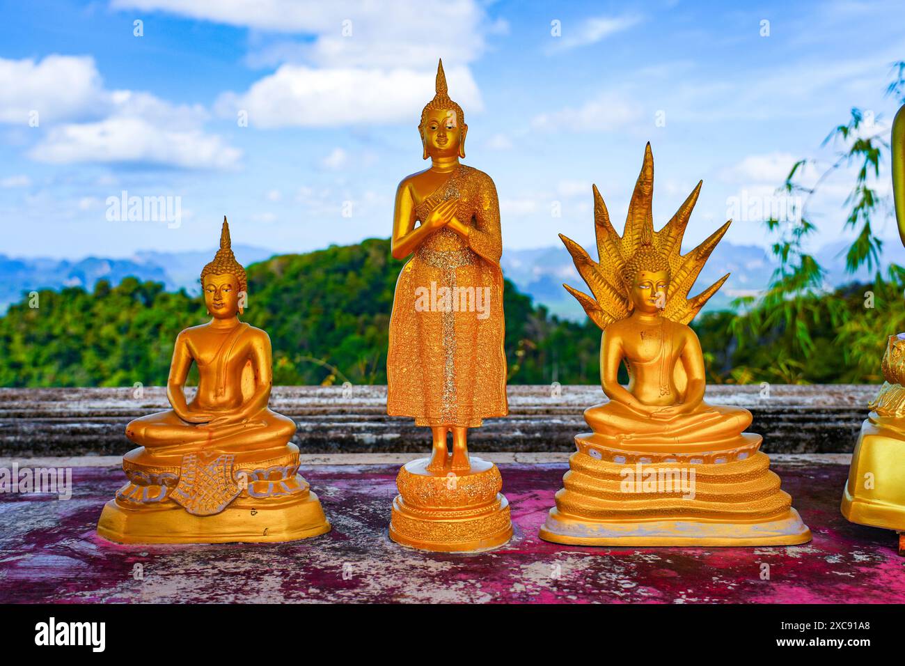 Trio of golden Buddha statues in several postures at the hilltop pagoda ...