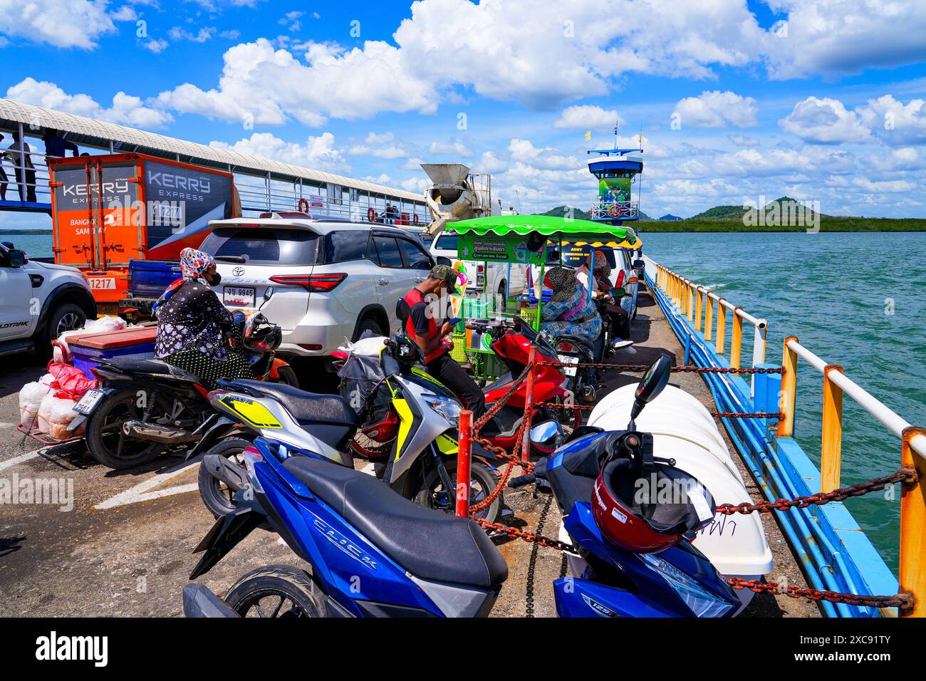 Thai locals waiting on their scooters on the ferry crossing the Andaman ...
