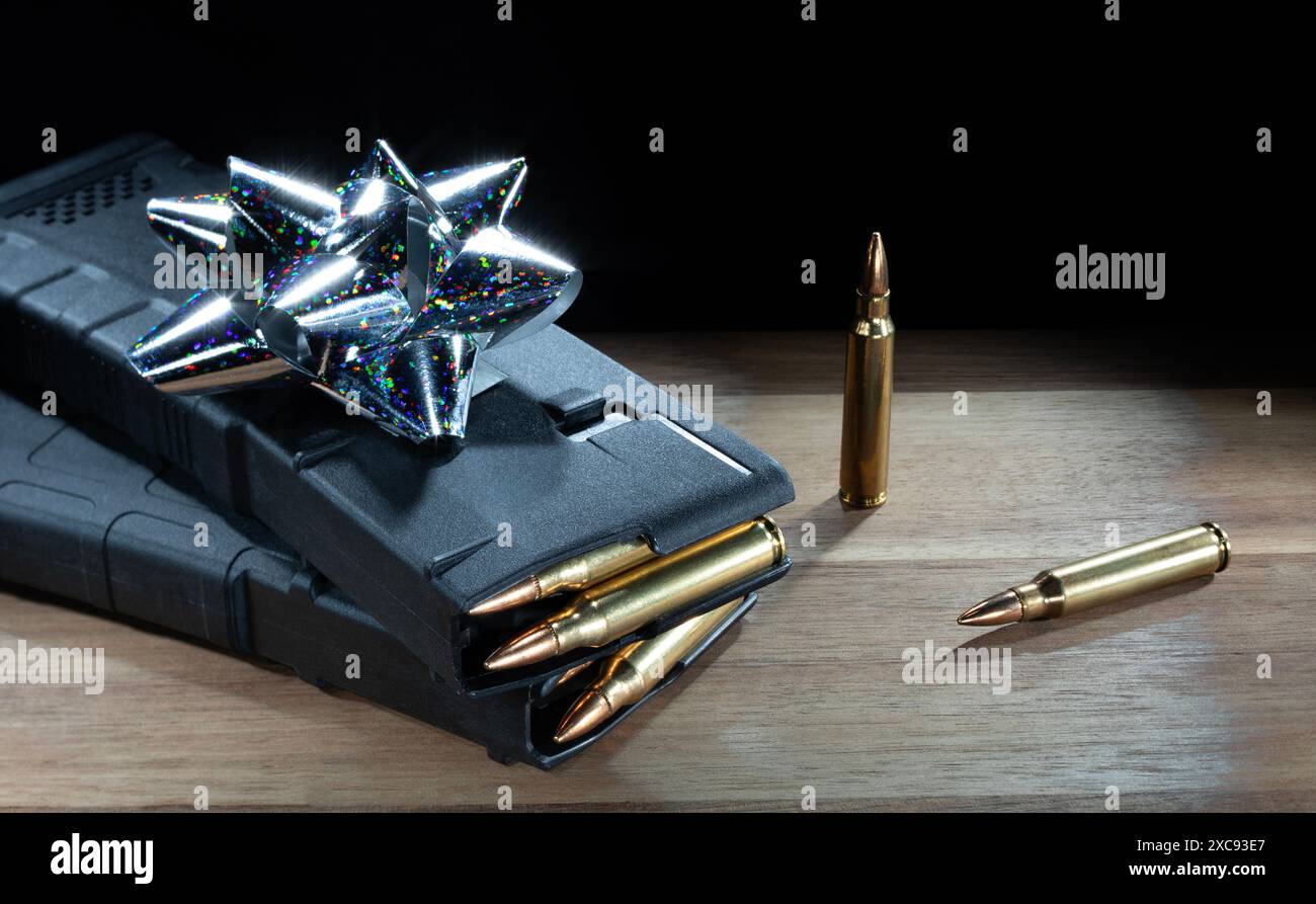 Two AR-15 magazines filled with 30 cartridges underneath a silver and ...