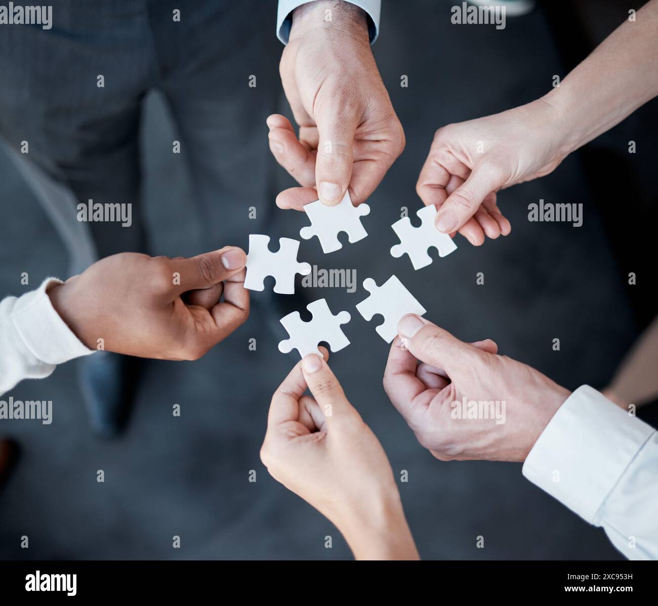Hands, puzzle and above for teamwork in office with business people ...