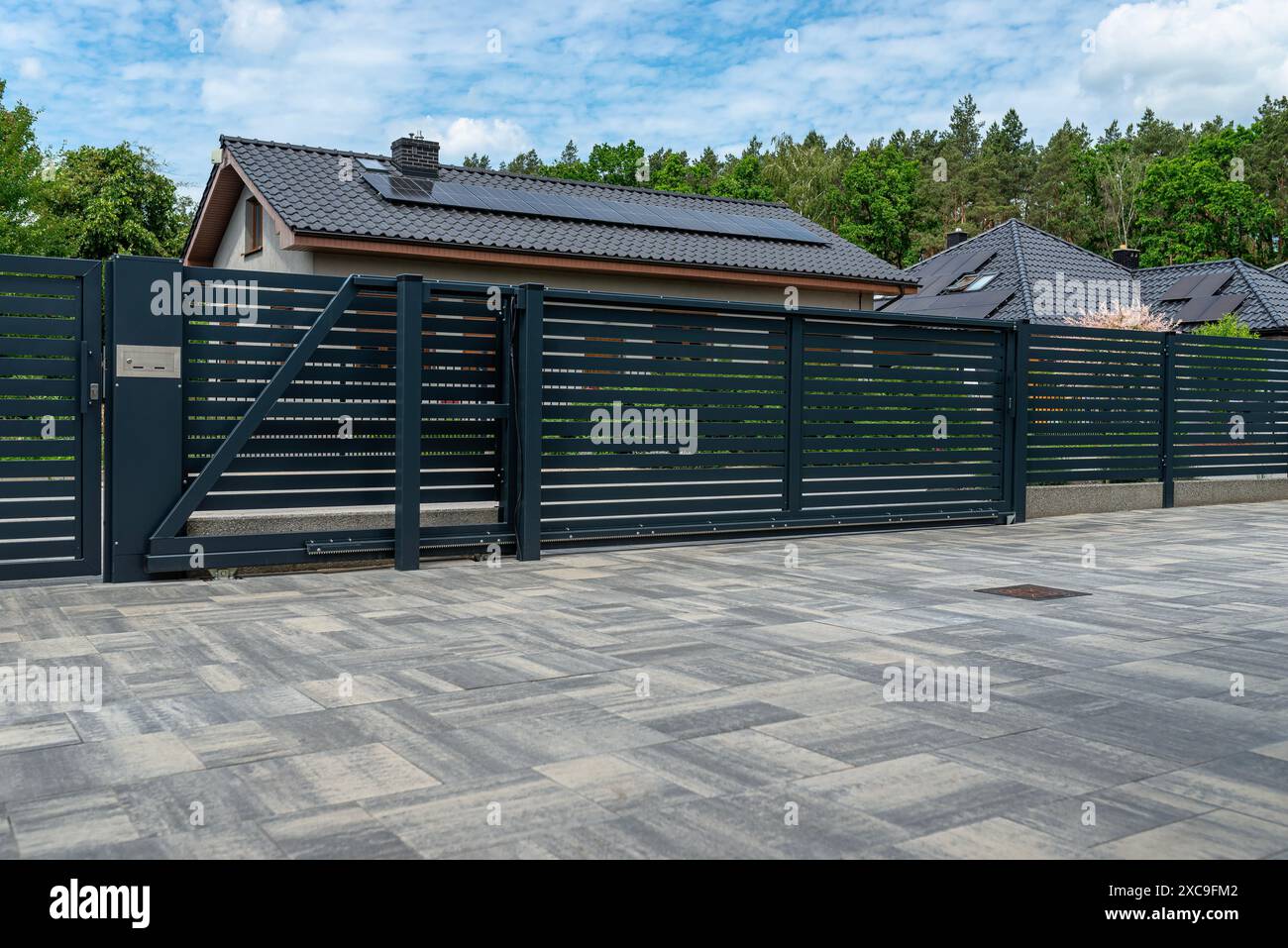 A modern panel fence in anthracite color, visible sliding gate to the ...